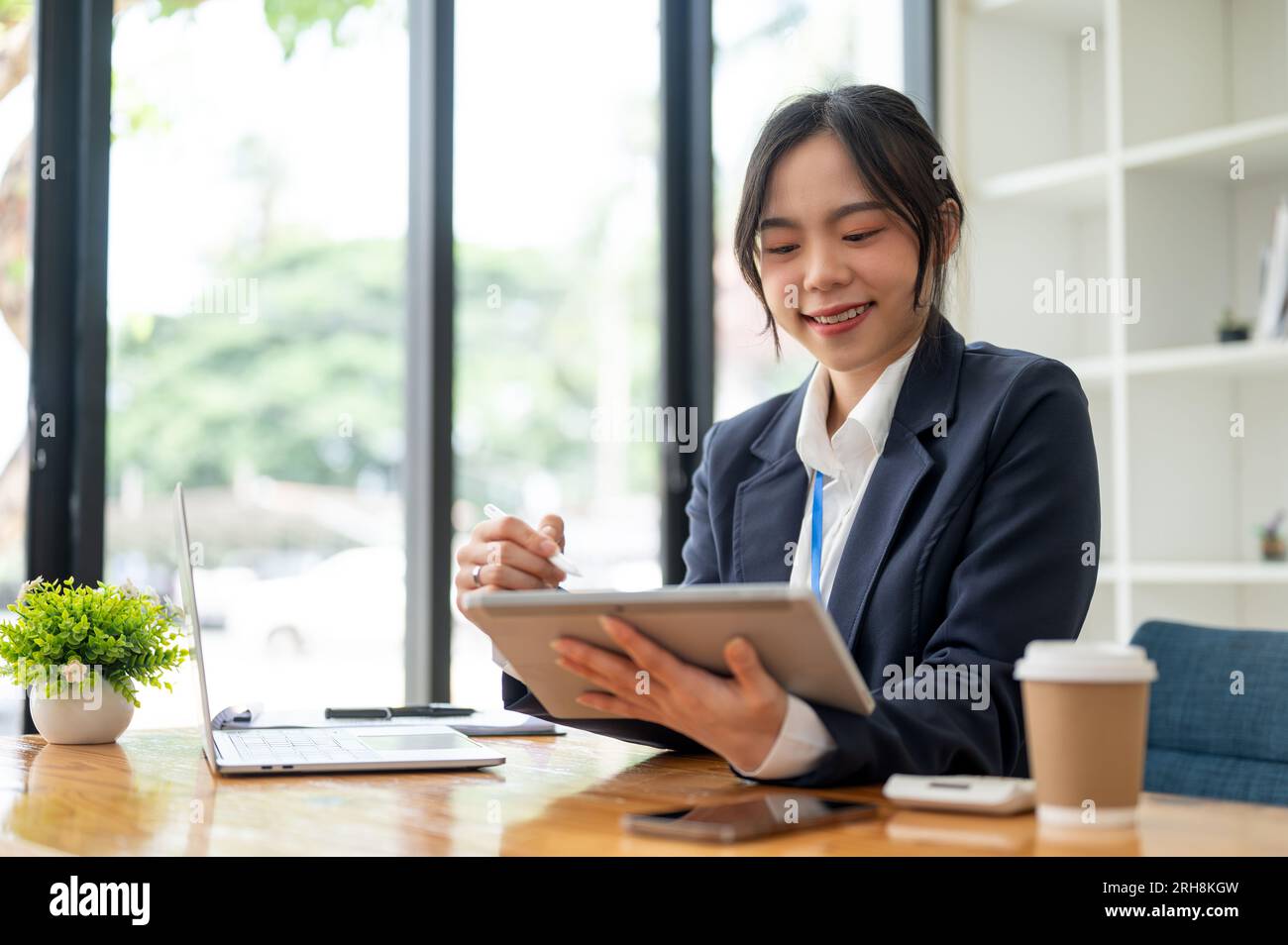 A beautiful Asian businesswoman or female accountant is using her ...