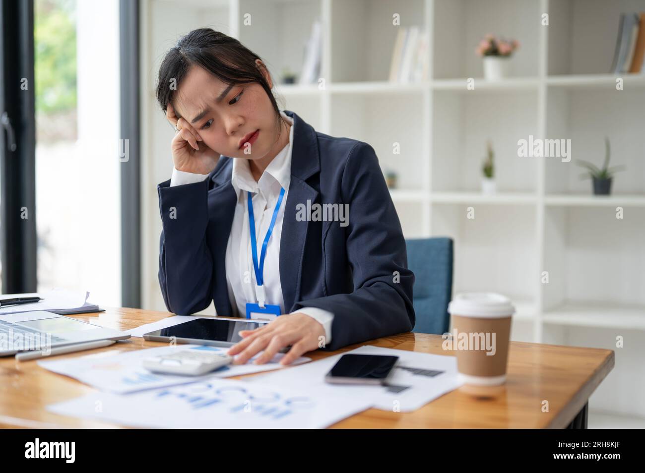 A confused and perplexed Asian businesswoman or accountant reading ...