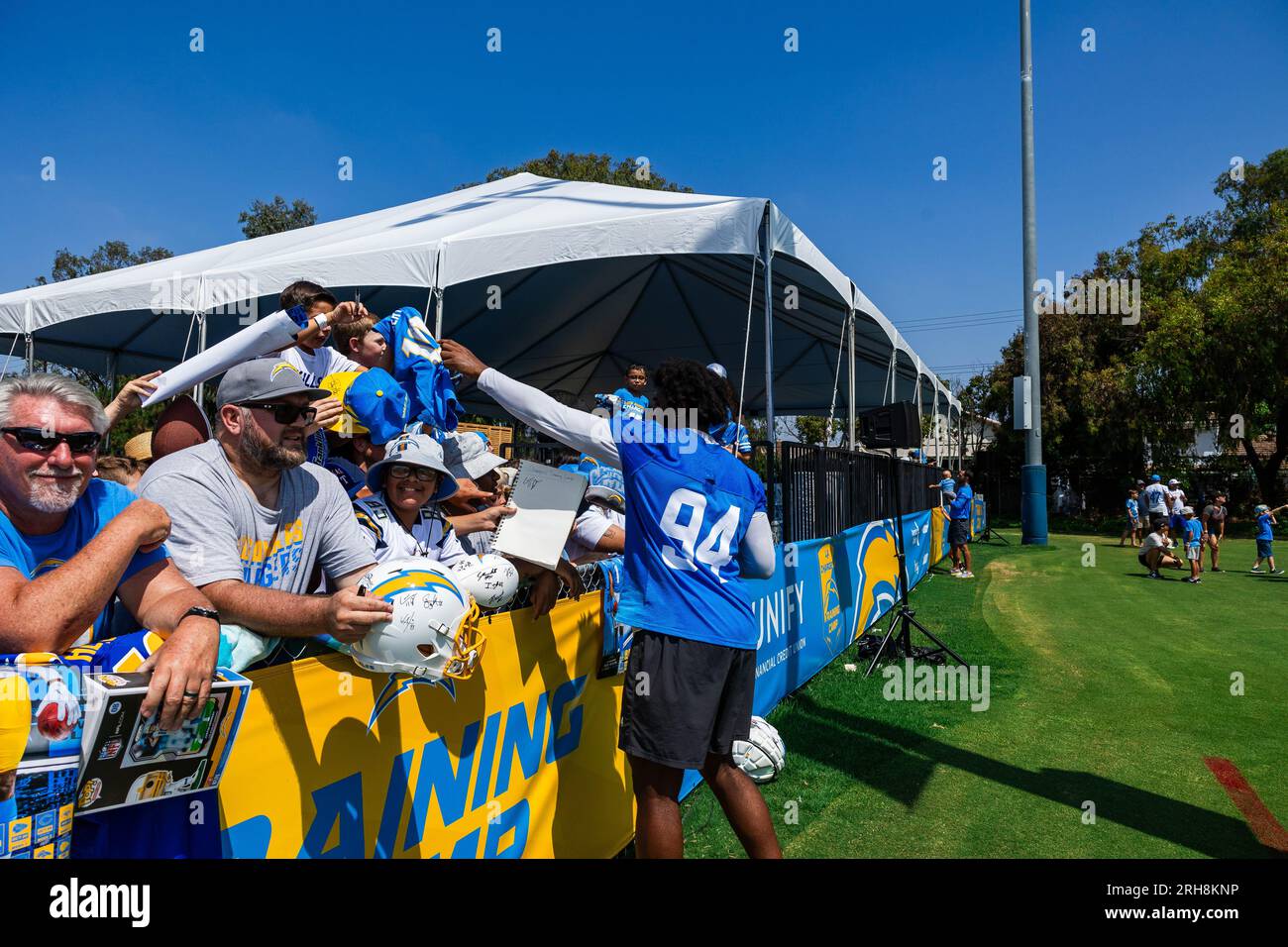 Los Angeles Chargers line backer Chris Rumph II (94) give autographs to ...