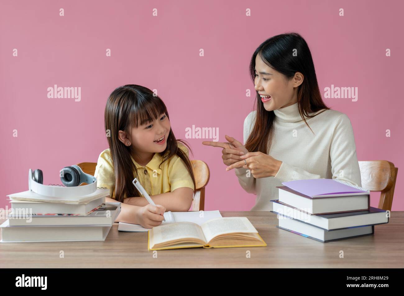 A kind and caring Asian female teacher or sister helps a young ...