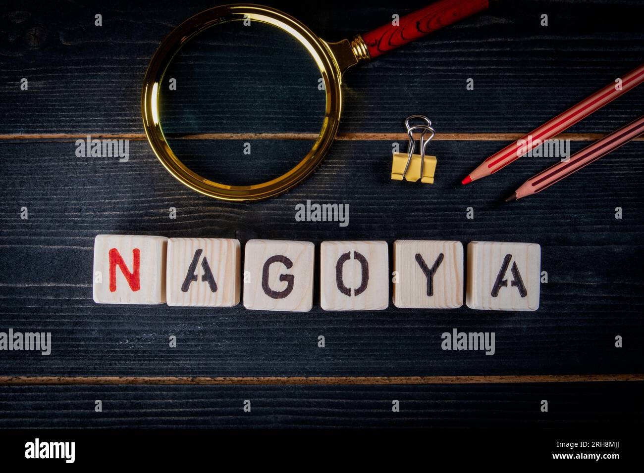 NAGOYA. City name from alphabet letters on dark wood texture background ...