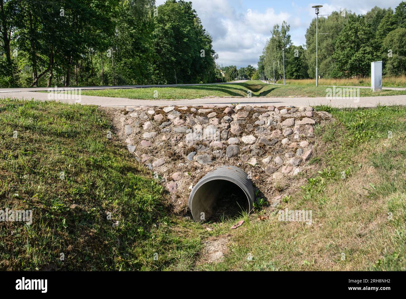 Trough the pipe. Stormwater and road infrastructure ditch Stock Photo ...