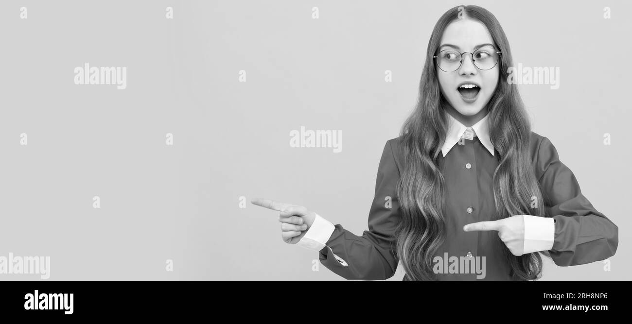 Surprised kid point fingers yellow background. Pointing for advertising ...