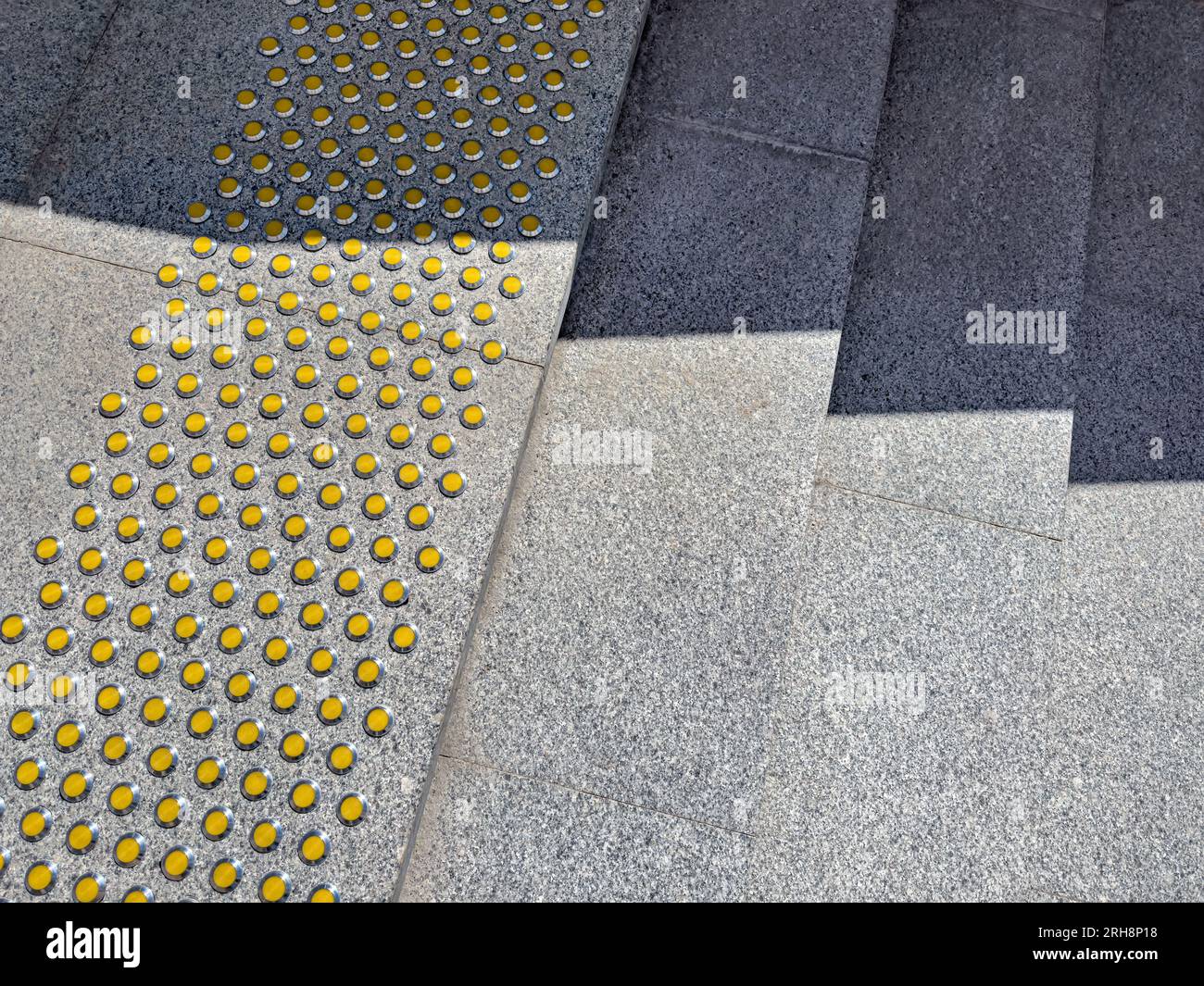 modern granite staircase with yellow nonskid bumpy markings. closeup ...