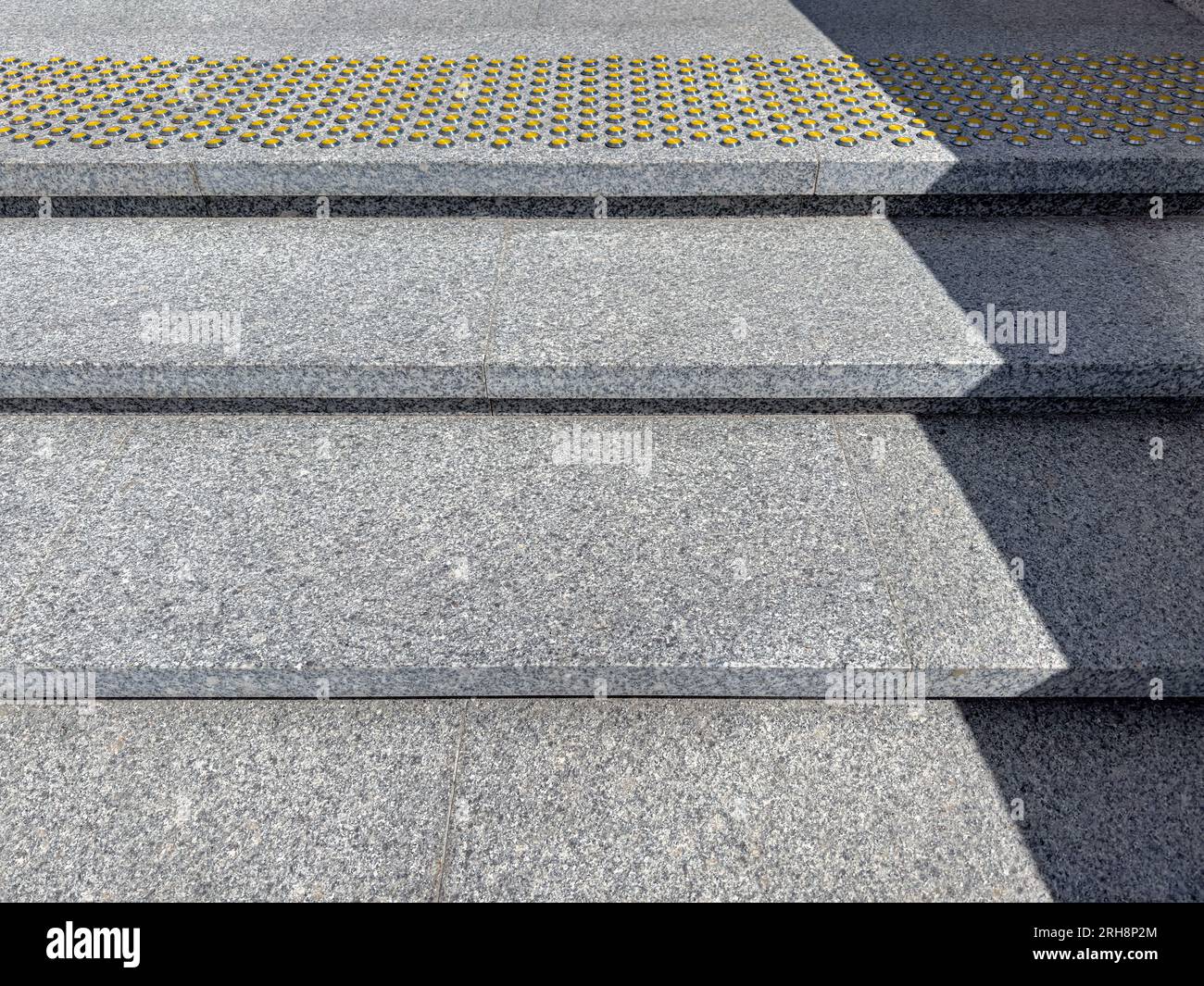 outdoors granite staircase with yellow nonskid bumpy markings on steps ...