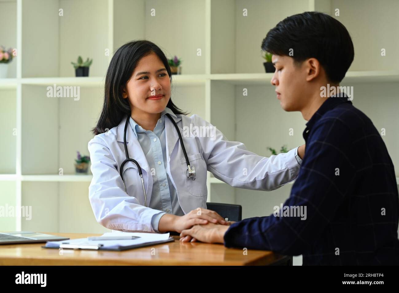 Caring female doctor touching male patient shoulder, giving empathy ...