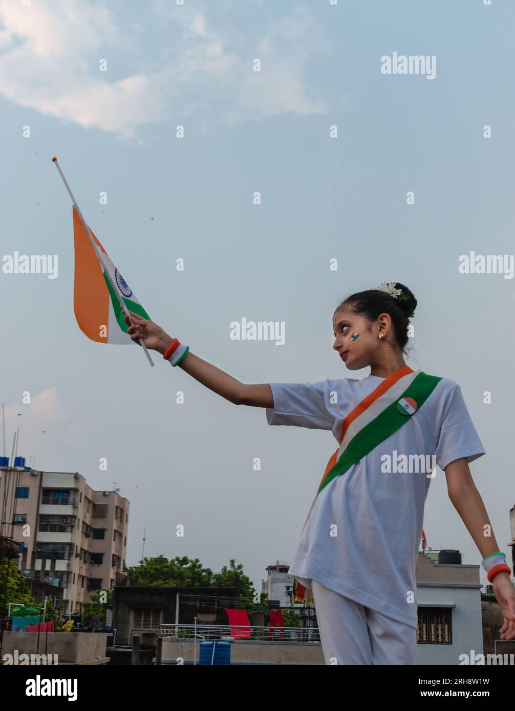 Cute Indian girl kid holding Indian flag against sky celebrating Indian ...