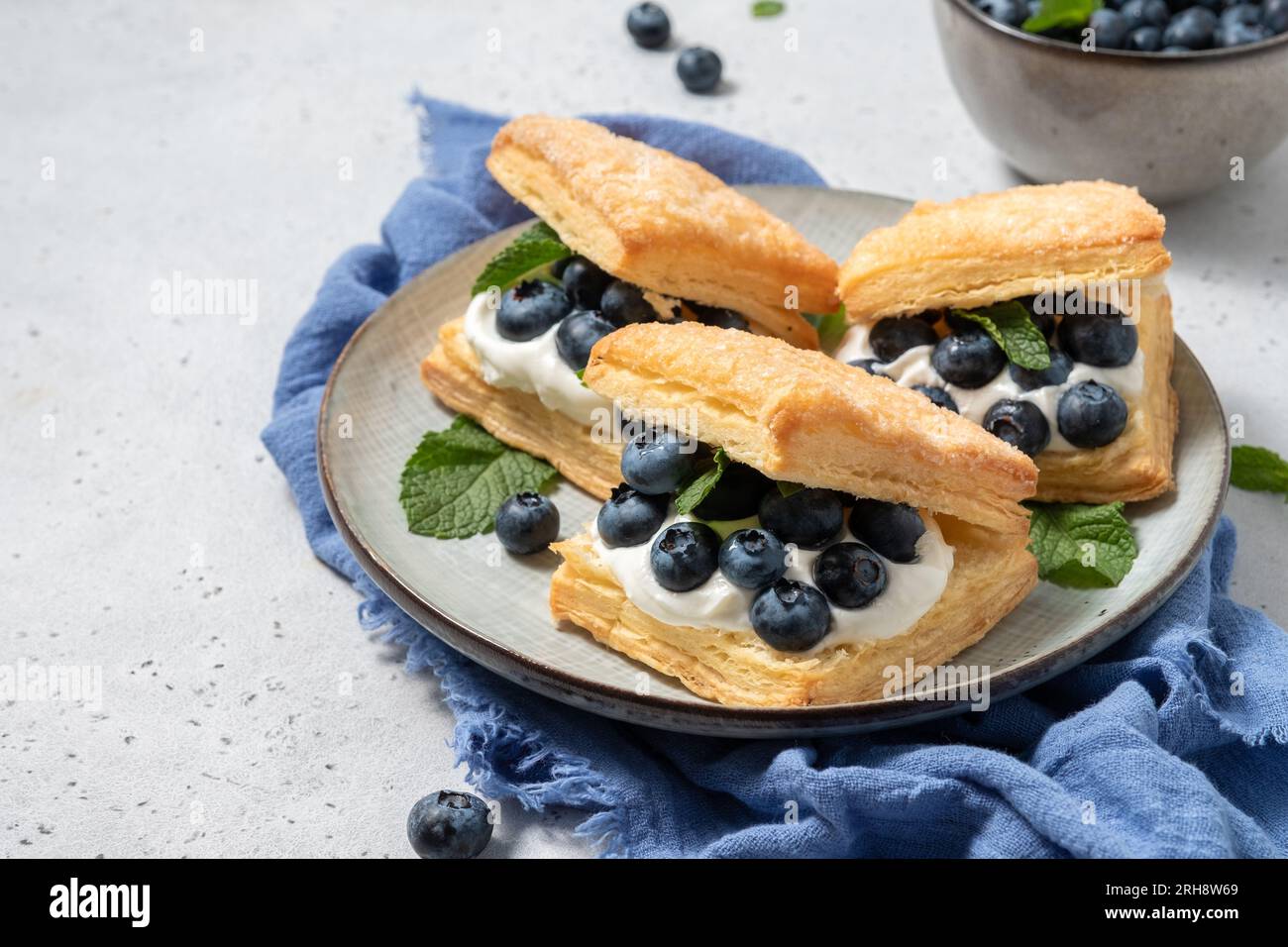 Stuffed homemade puff cookies with whipped cream and blueberries Stock ...