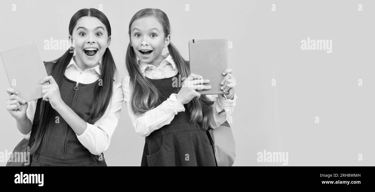 School girls friends. Read me story. Surprised kids hold books yellow ...