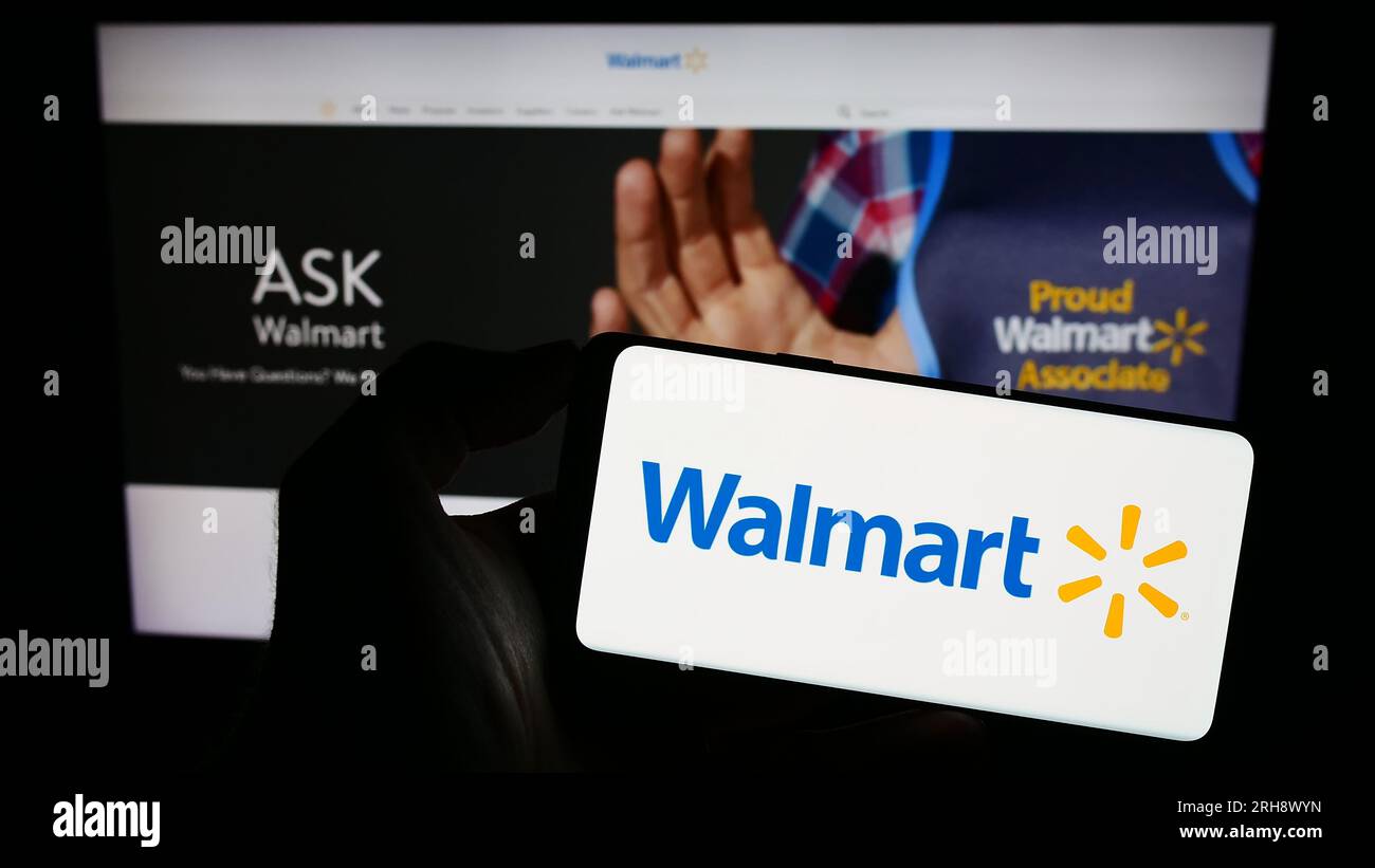 Person holding smartphone with logo of US retail company Walmart Inc ...