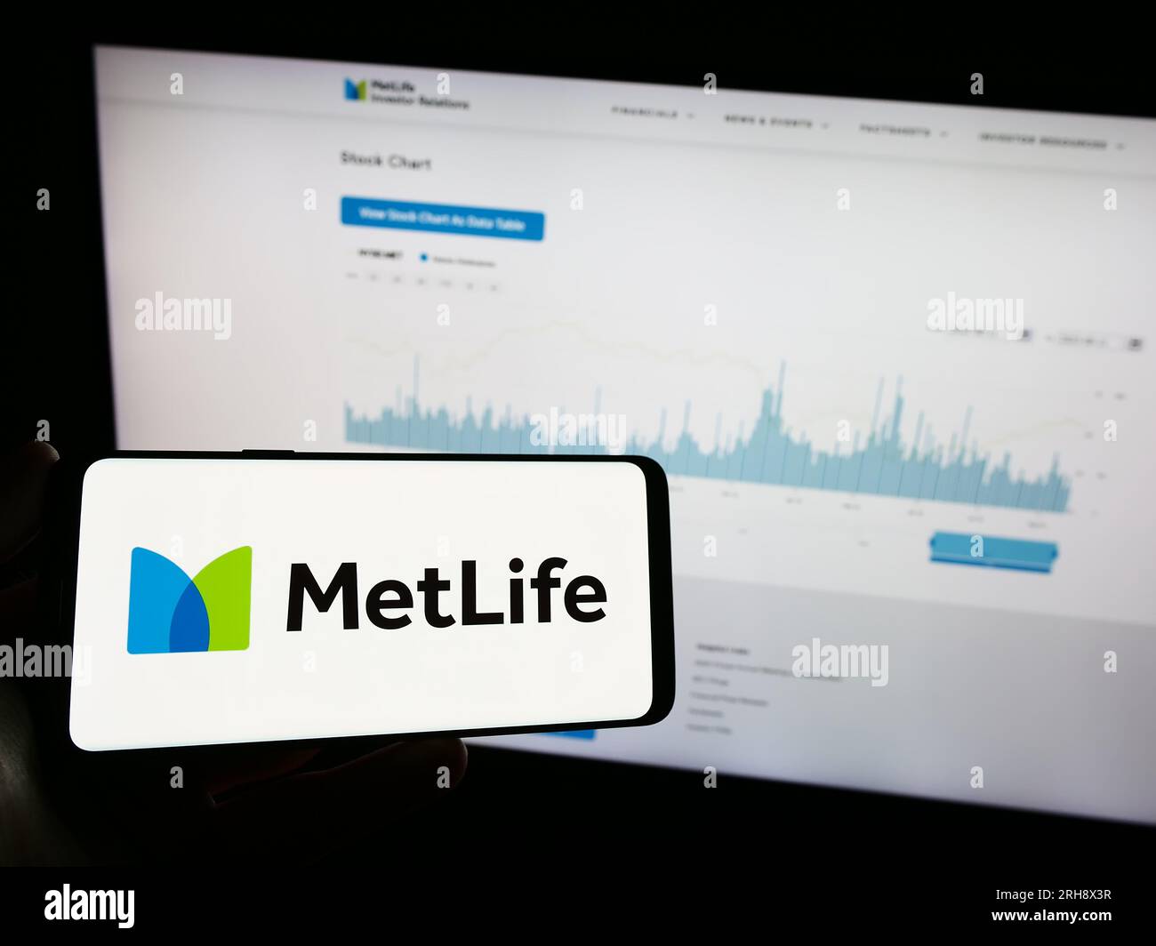 Person holding mobile phone with logo of American insurance company ...