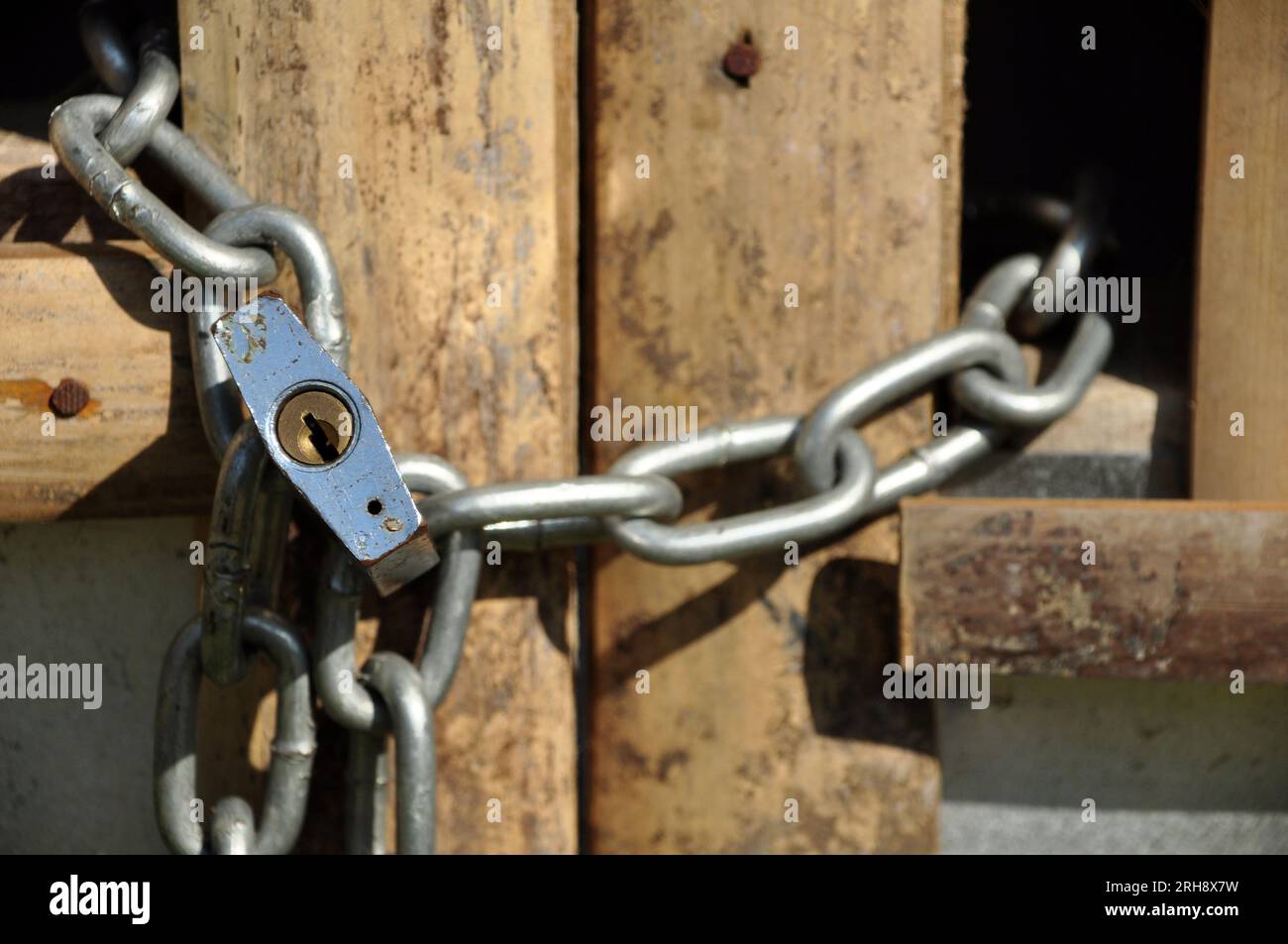Chain padlock lock on a fence made of bamboo Stock Photo - Alamy