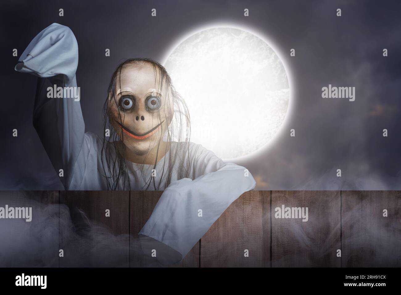Scary Momo standing behind the wooden fence with a night scene ...