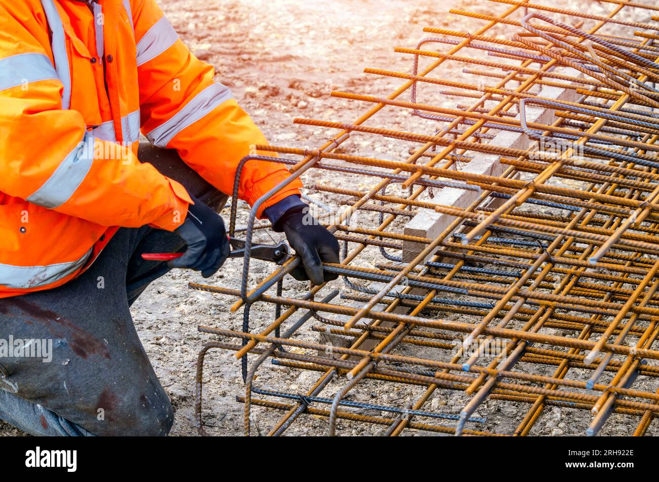 Steel fixer assembling reinforcement cage off rebars. Selective focus ...
