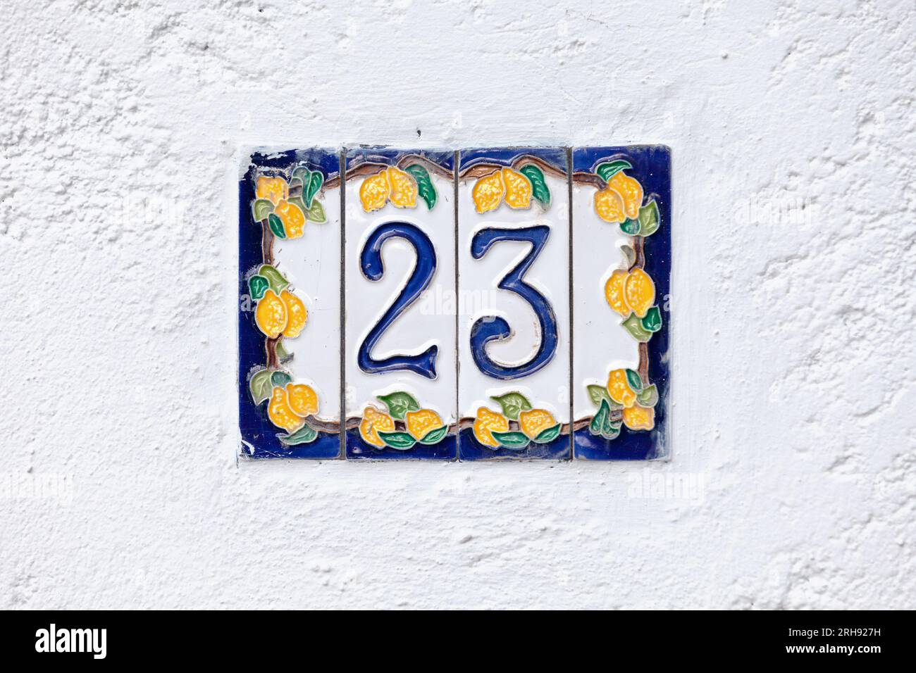 Close-up on a Number 23 in Faience on a concrete wall painted white ...