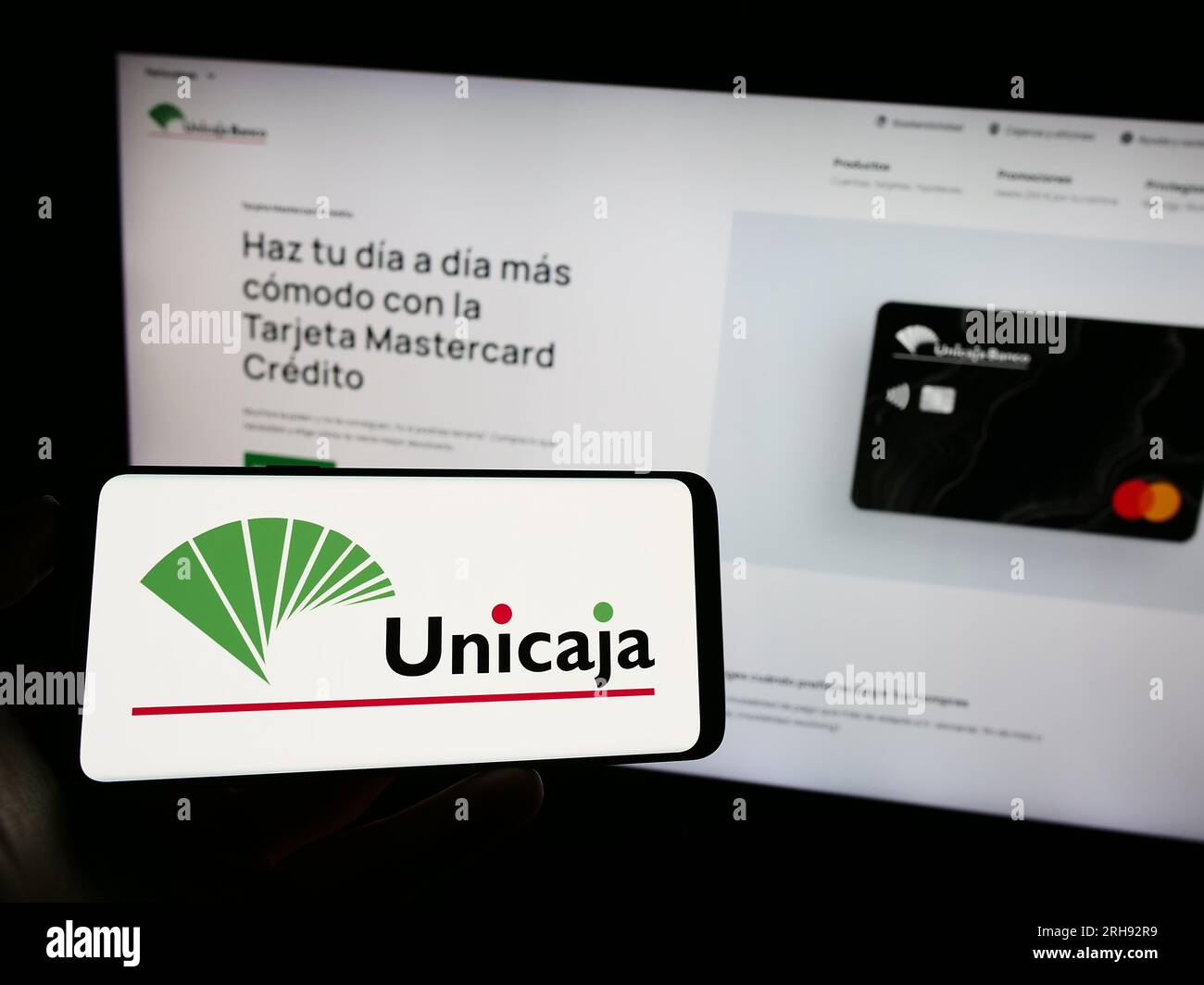 Person holding mobile phone with logo of Spanish banking company ...