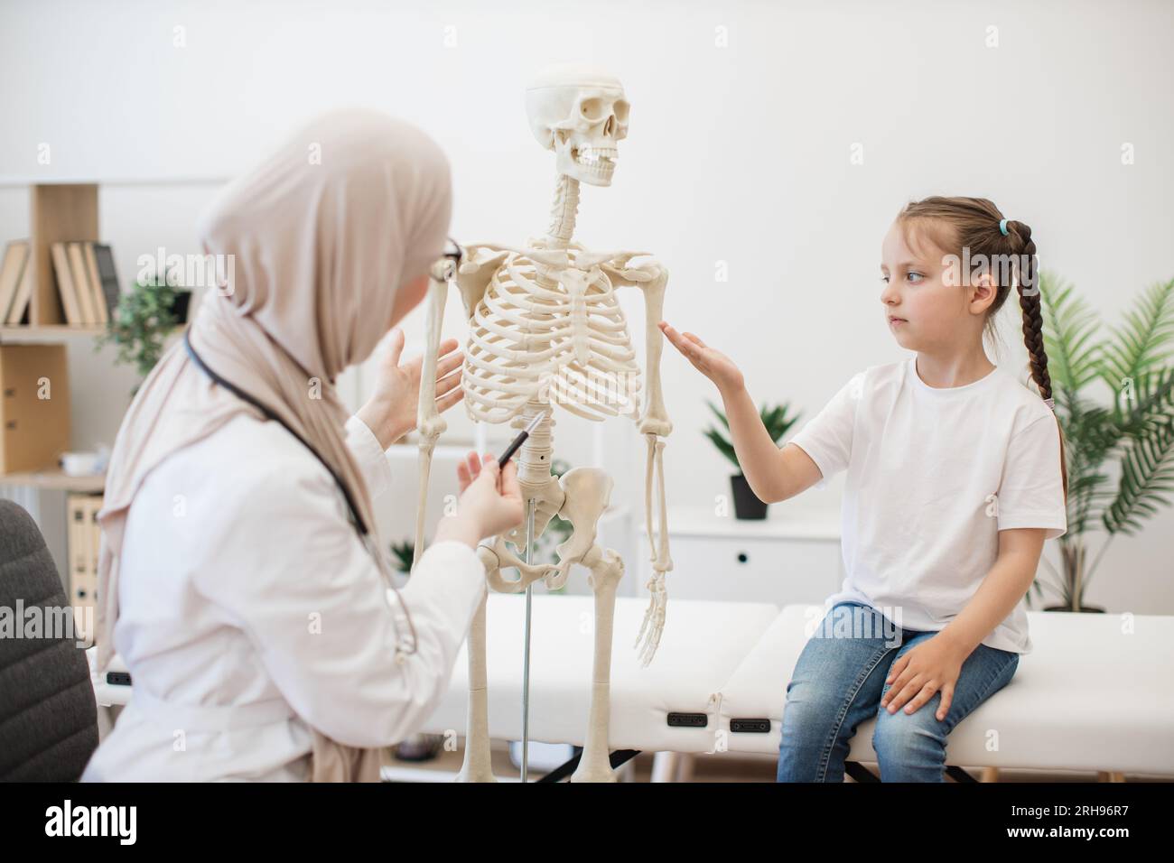 Close up view of tween caucasian girl pointing at ribs on skeleton ...