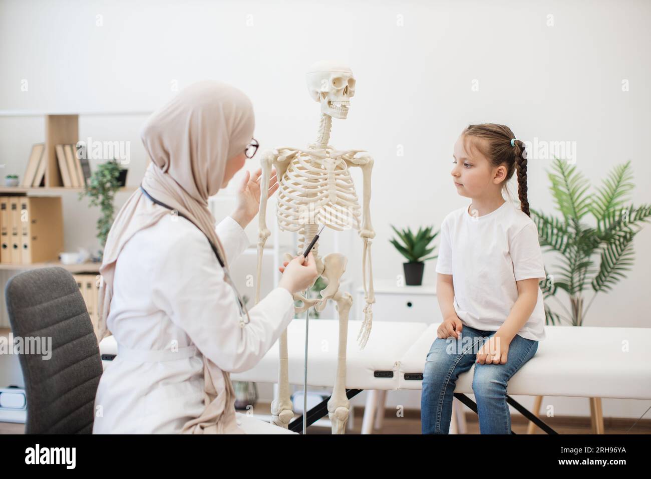 GP consulting tween kid about human body by anatomical model Stock ...