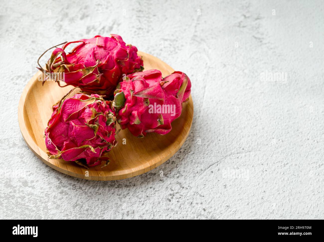 Ripe red dragon fruit on stone table Stock Photo - Alamy
