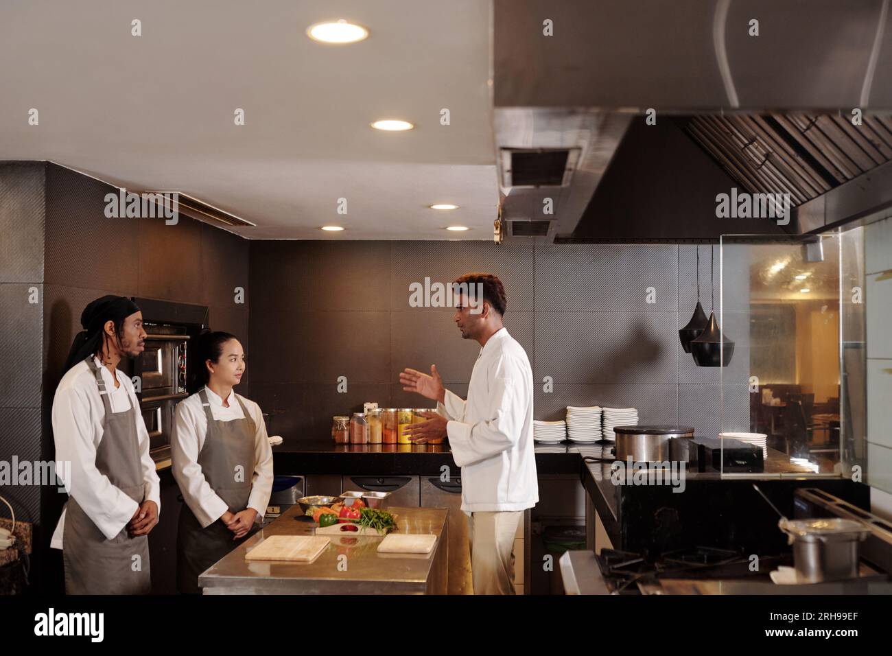 Restaurant chef explaining processes to his new team Stock Photo - Alamy