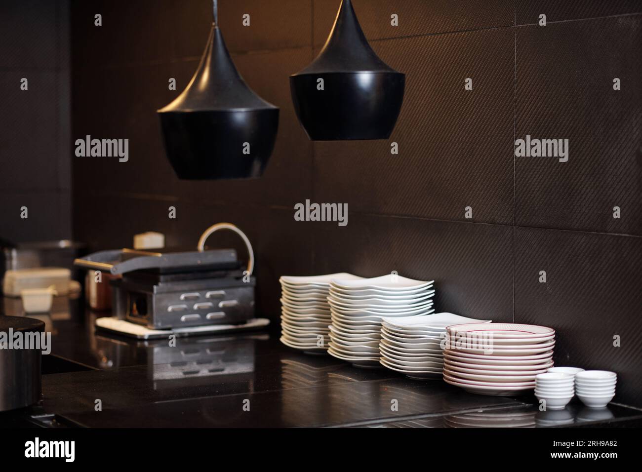 Stacked plates on counter in modern kitchen of restaurant Stock Photo ...