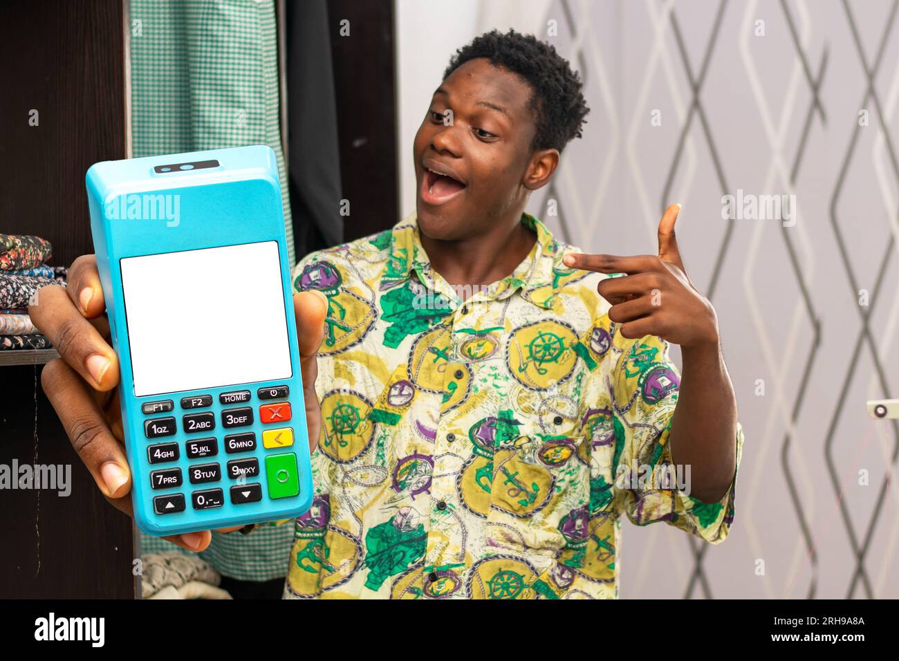 Photo of a black african man wearing fabric standing beside a fabric ...