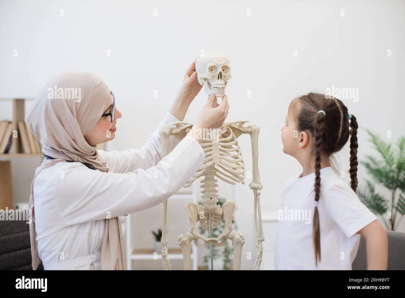 Therapist having fun with skull near preteen girl at work Stock Photo ...