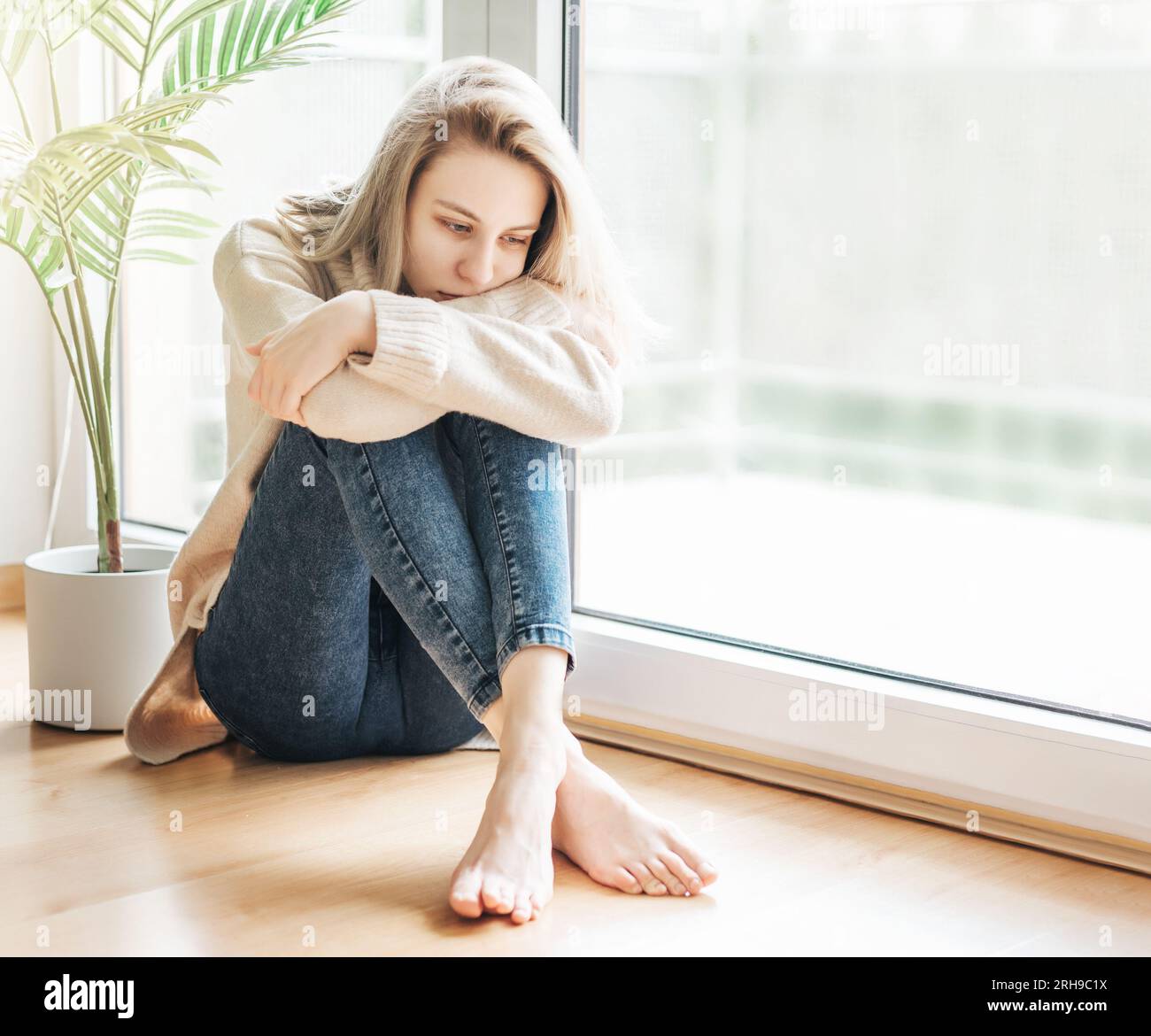 Sad girl near window thinking about something. Stressed lady feel ...