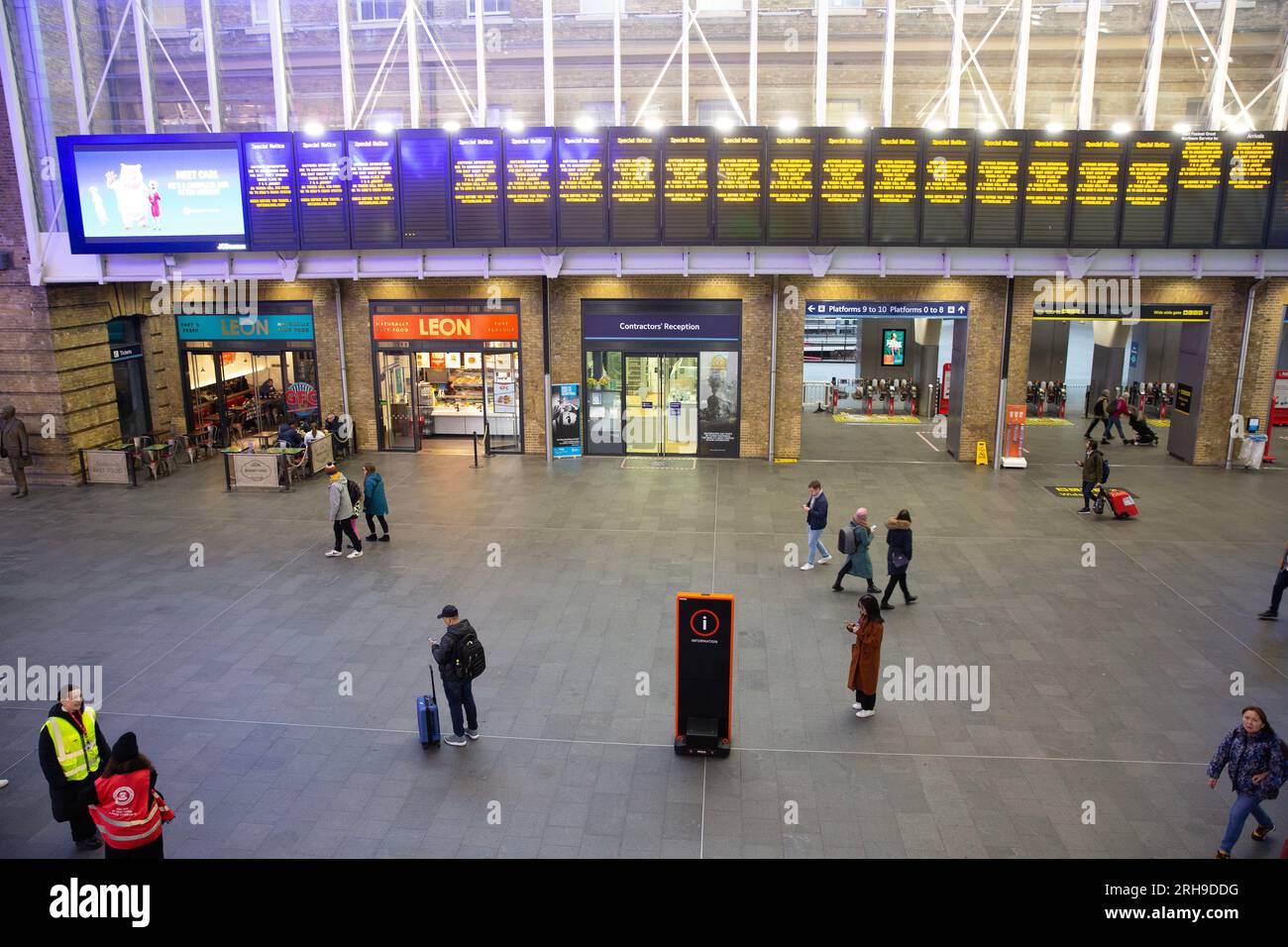 People walk in front of electric timetables at King’s Cross Station in ...