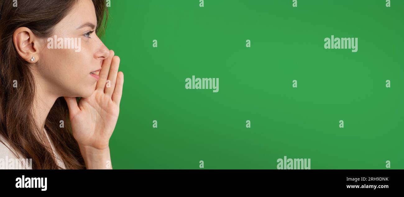 Serious european millennial woman puts hand to lips, whispers secret ...