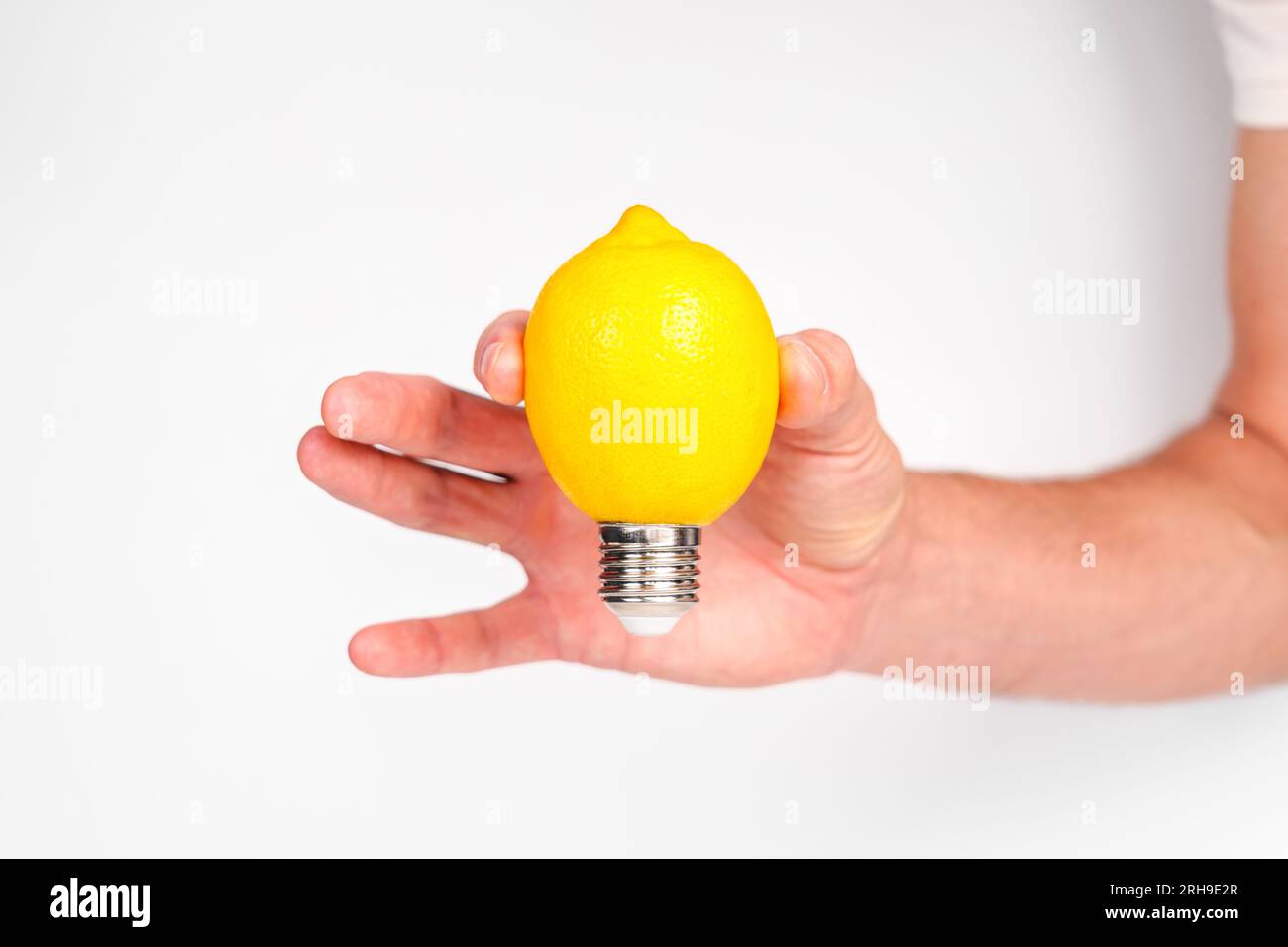 Lemon light bulb in hand on a white background. Creative abstract idea ...