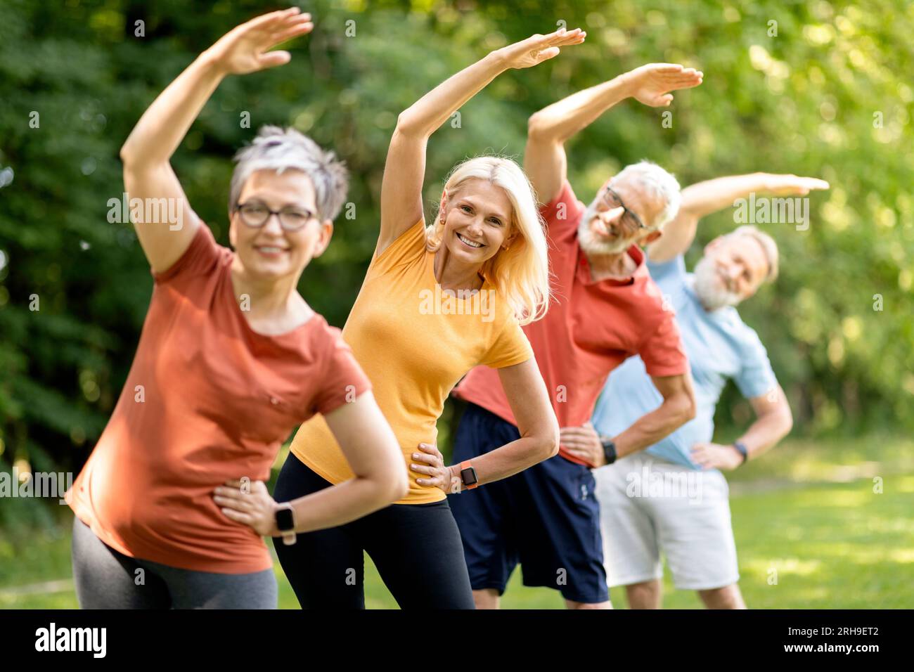 Group of sporty mature people doing stretching exercises at park Stock ...