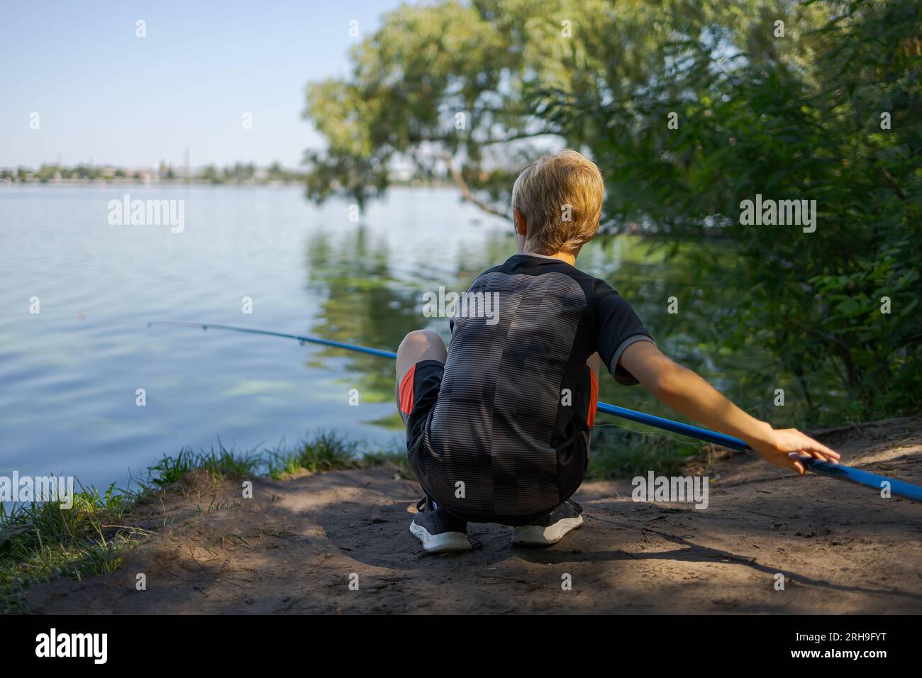 The boy prepared to hook the fish. Sport fishing on the river in summer ...