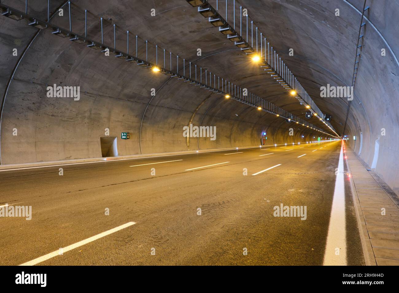 Modern new tunnel on a highway illuminated with lights and traffic ...