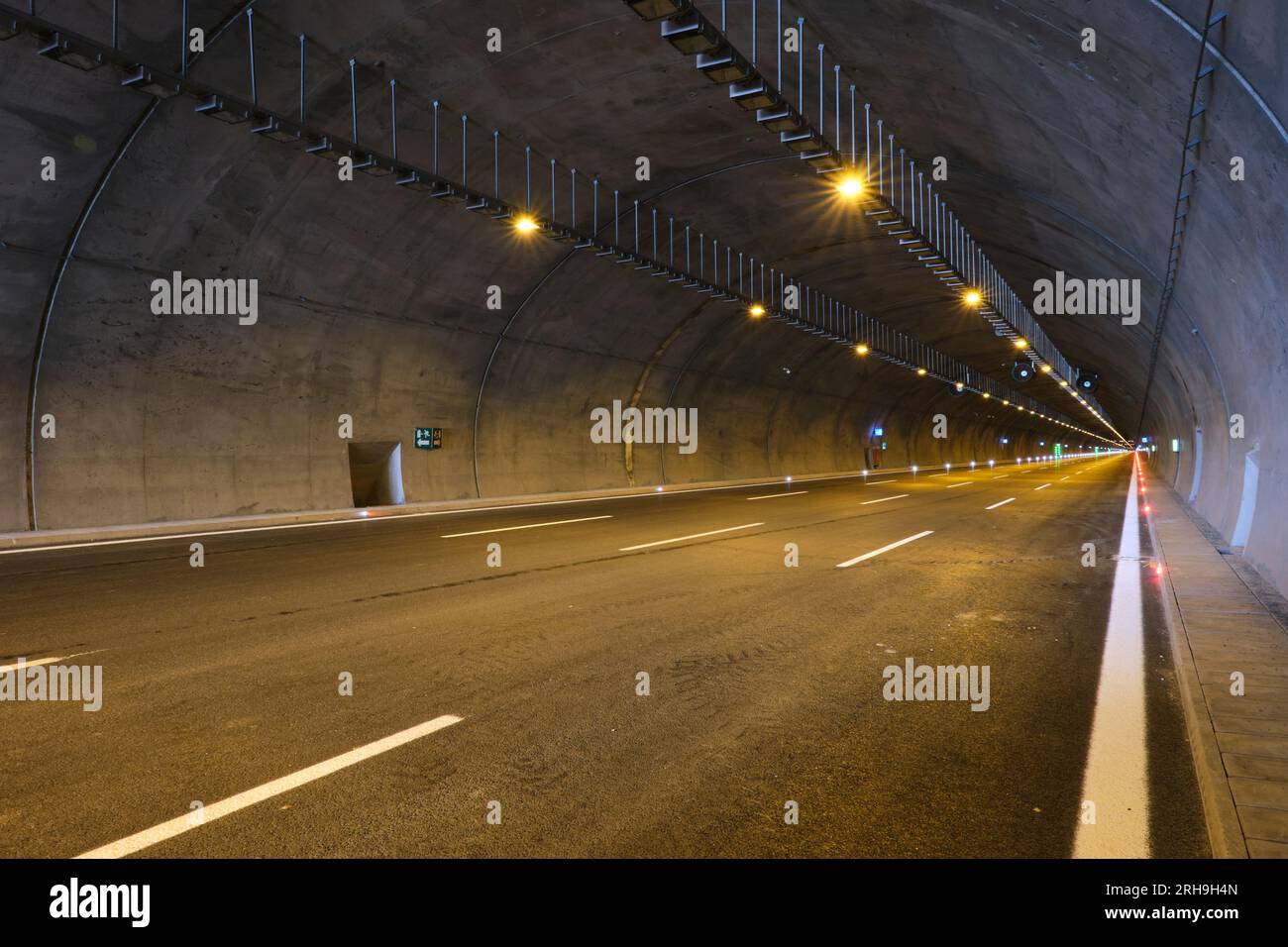 Modern new tunnel on a highway illuminated with lights and traffic ...