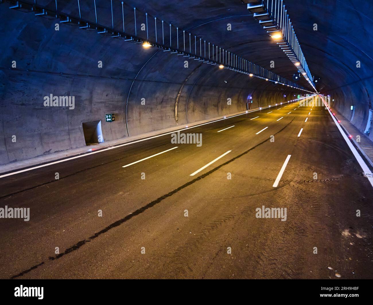 Modern new tunnel on a highway illuminated with lights and traffic ...