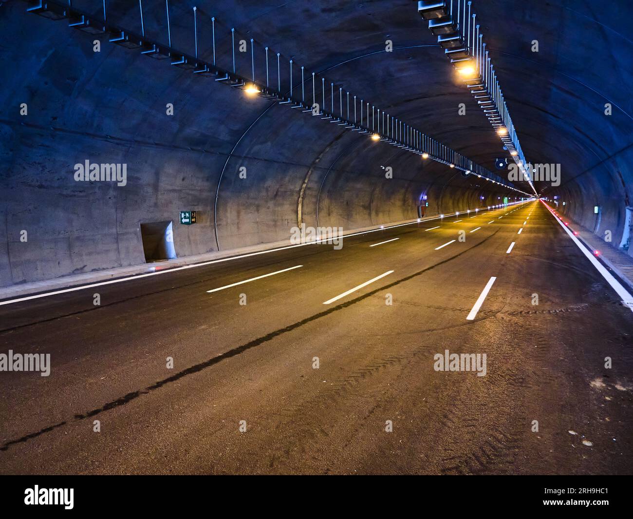 Modern new tunnel on a highway illuminated with lights and traffic ...