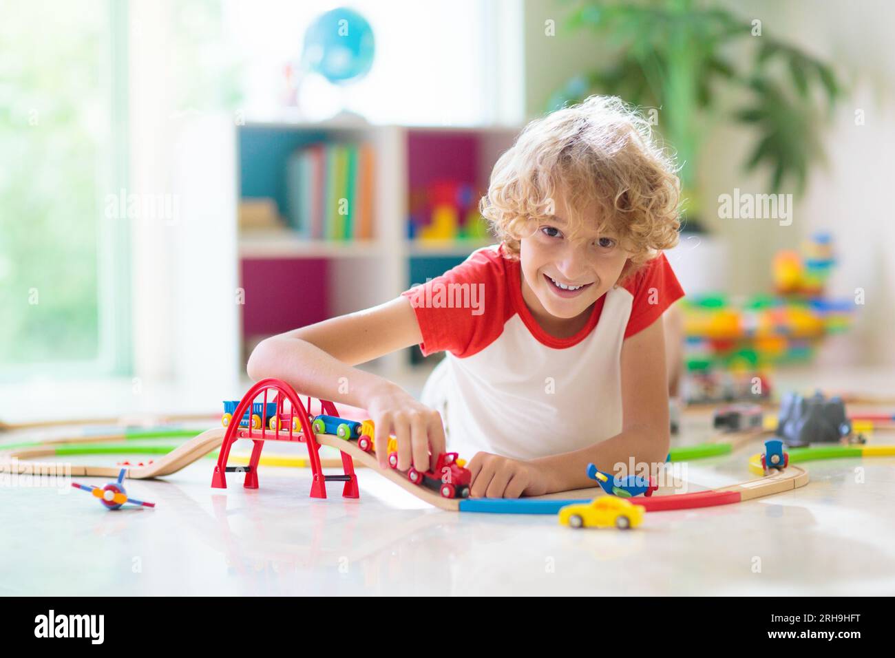Kids play with toy train railway. Child playing with colorful rainbow ...