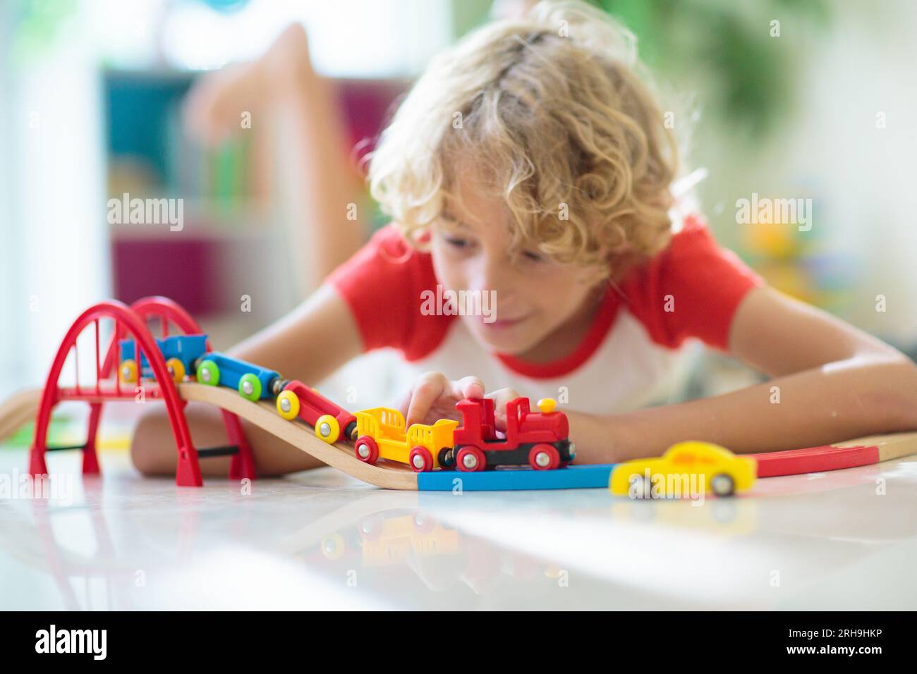 Kids play with toy train railway. Child playing with colorful rainbow ...