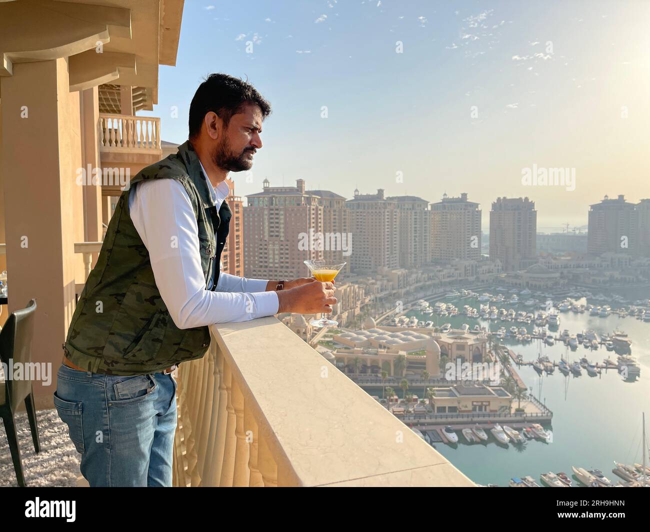 Young Men enjoying view of Peral Qatar Porto Arabia from Balcony Stock ...