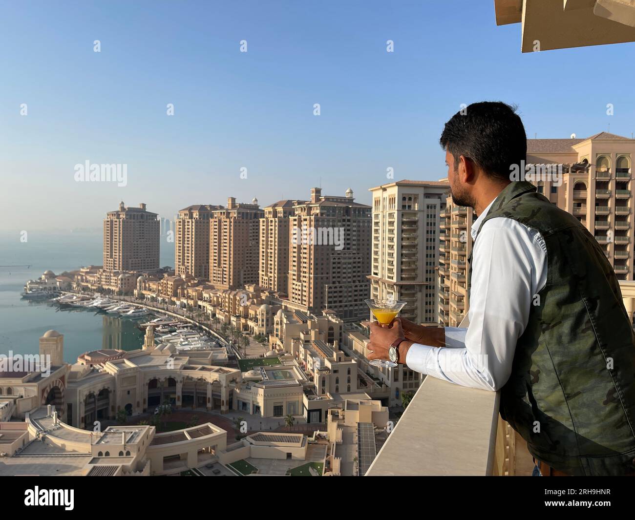 Young Men enjoying view of Peral Qatar Porto Arabia from Balcony Stock ...