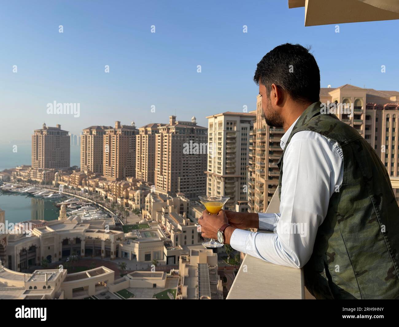 Young Men enjoying view of Peral Qatar Porto Arabia from Balcony Stock ...