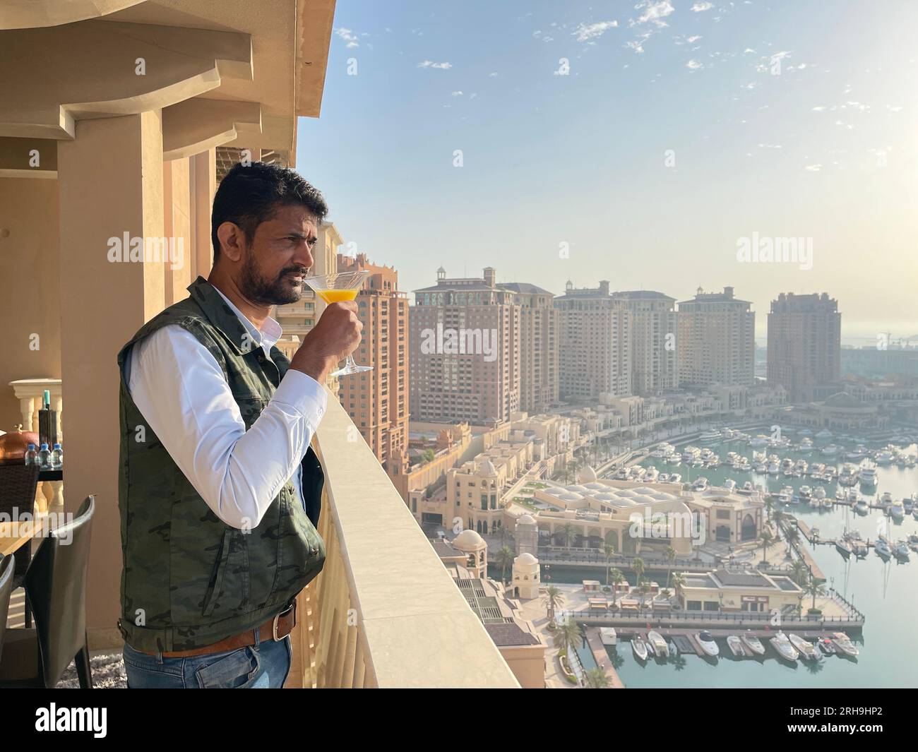 Young Men enjoying view of Peral Qatar Porto Arabia from Balcony Stock ...