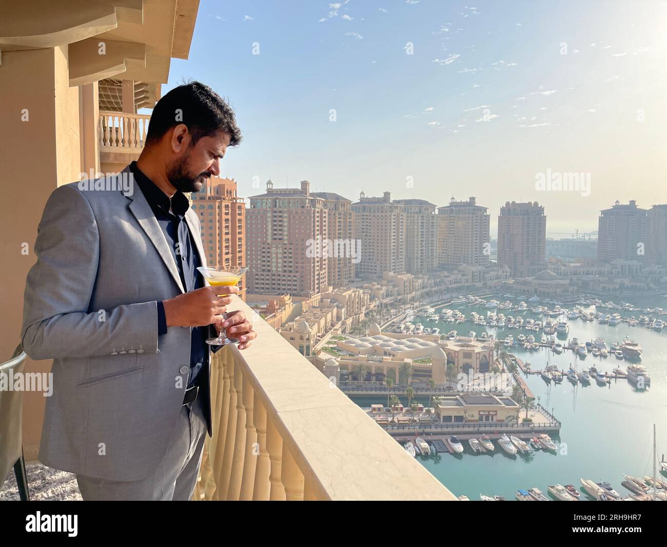 Young Men enjoying view of Peral Qatar Porto Arabia from Balcony Stock ...