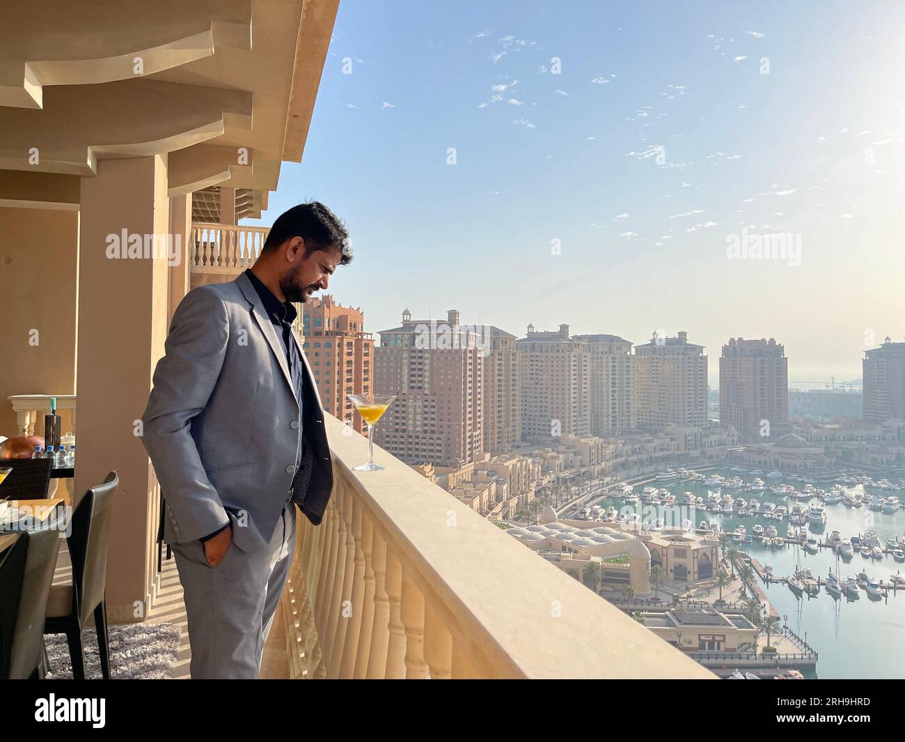 Young Men enjoying view of Peral Qatar Porto Arabia from Balcony Stock ...