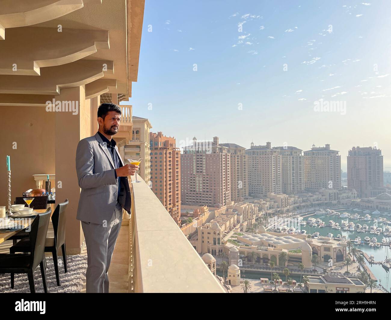 Young Men enjoying view of Peral Qatar Porto Arabia from Balcony Stock ...