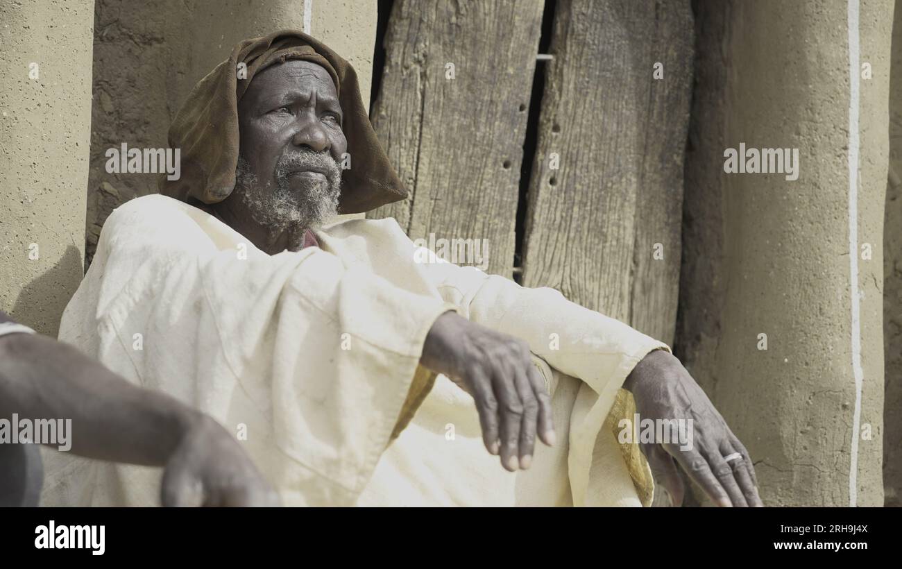 Mali- Elder African village leader with one blind white eye holding a ...