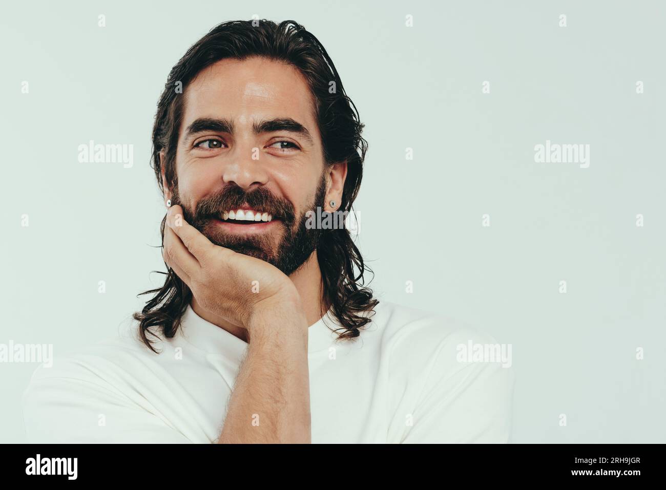 Handsome young man smiling in a studio, proudly wearing his beautiful ...