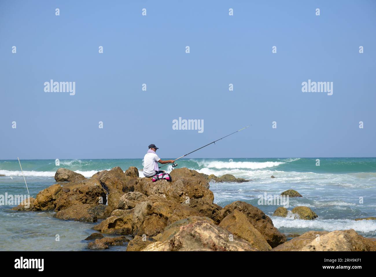 An Israeli man fishing at the beautiful beach in Bat Yam, Israel Stock ...