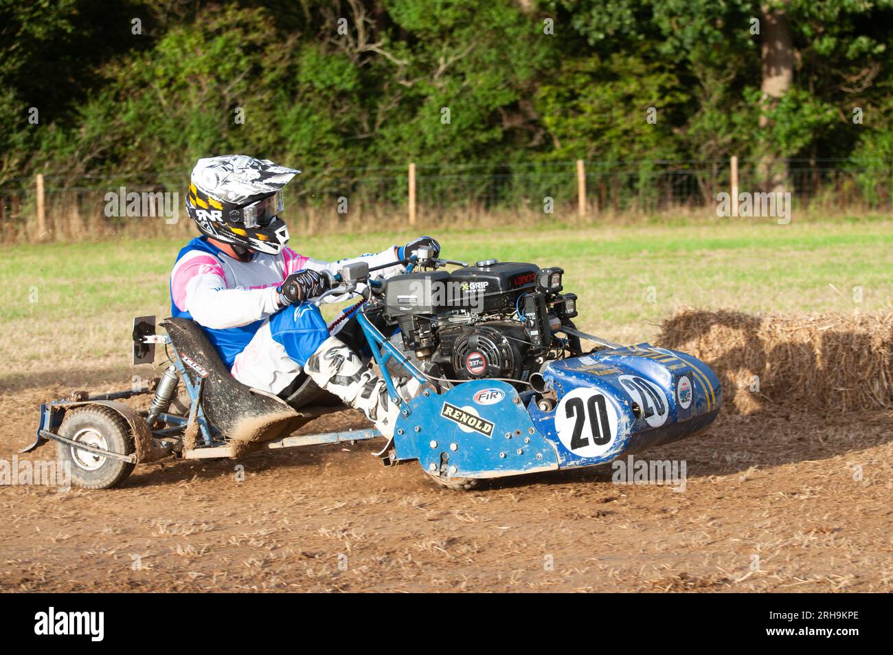 A racing lawn mower driver from "Nemo Racing" turns a corner in the ...